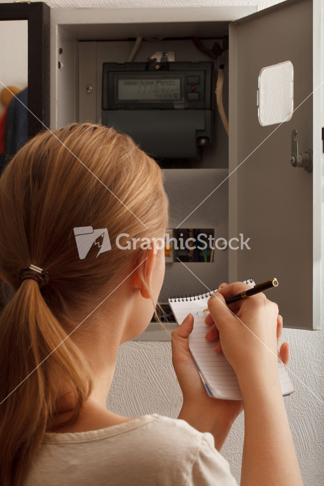 Young woman rewrites the electrical meter readings - Stock Image ...